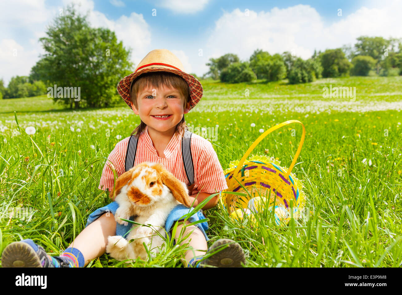 Small boy wearing hat and hugging rabbit Stock Photo - Alamy