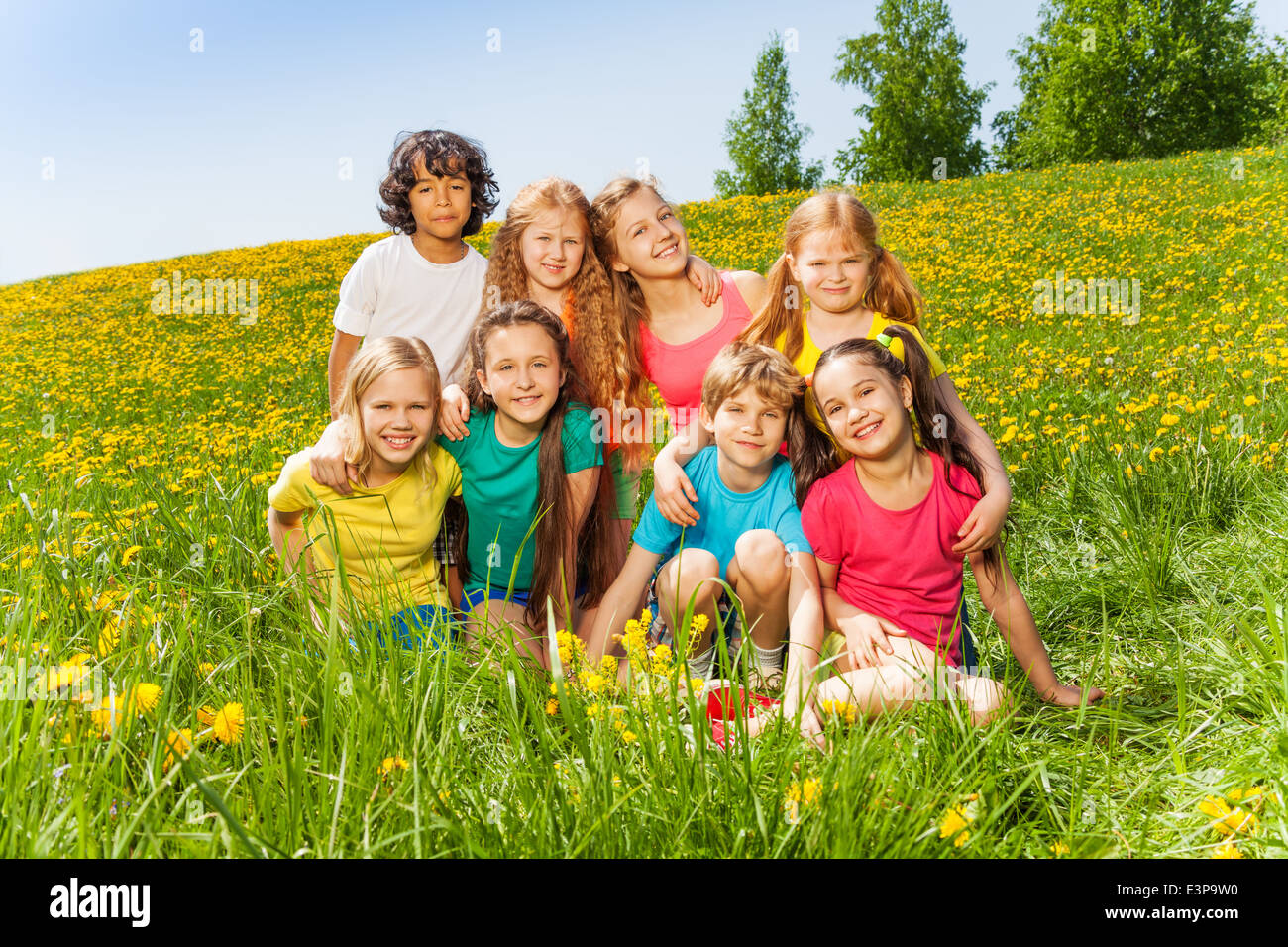 Eight kids sitting together on the green grass Stock Photo - Alamy