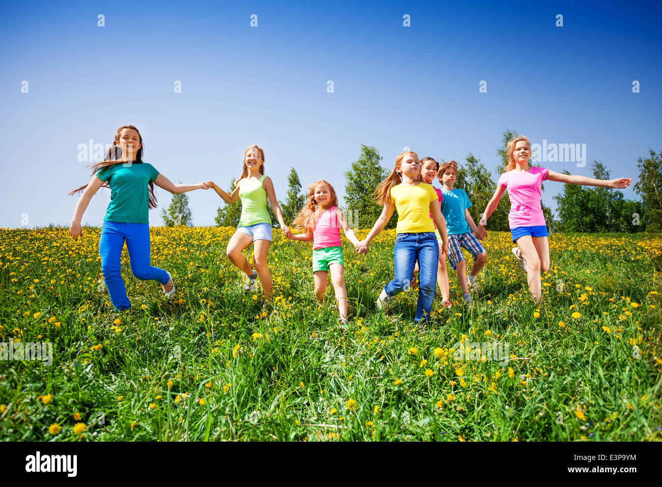 Happy children run and hold hands in green meadow Stock Photo - Alamy