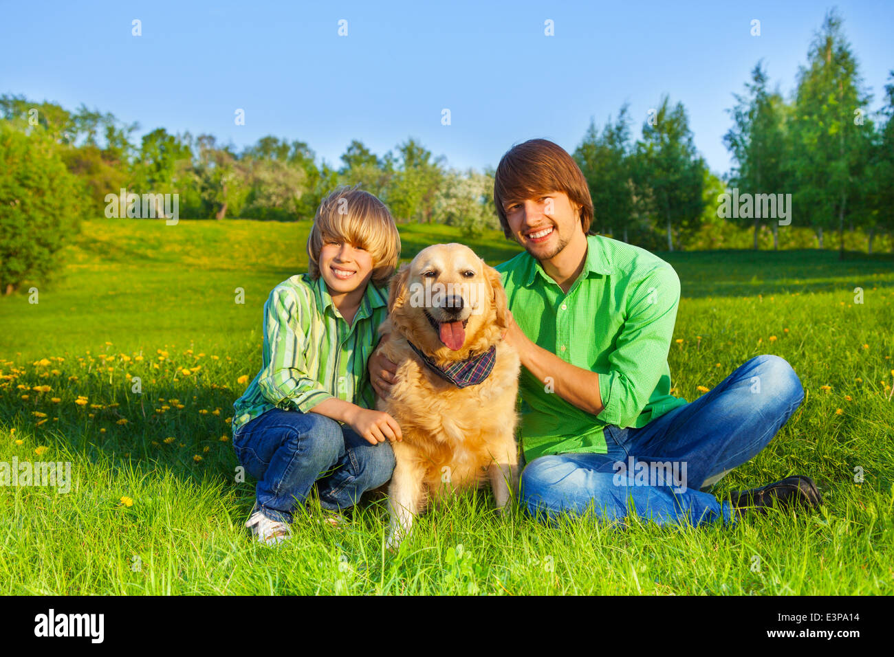 Happy kid, father and dog sit in park on grass Stock Photo - Alamy
