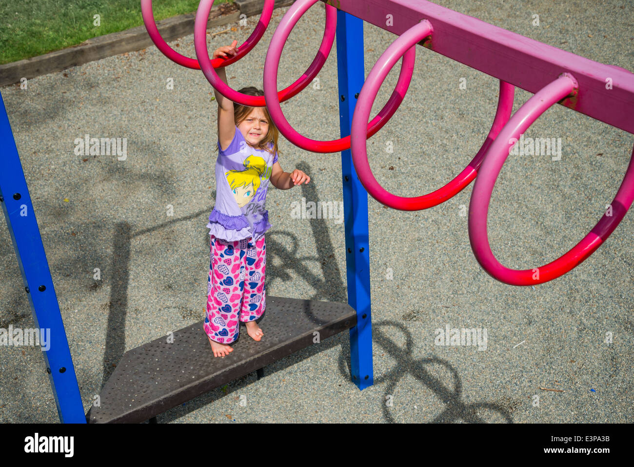 Young girl on playground rings, bars Stock Photo - Alamy
