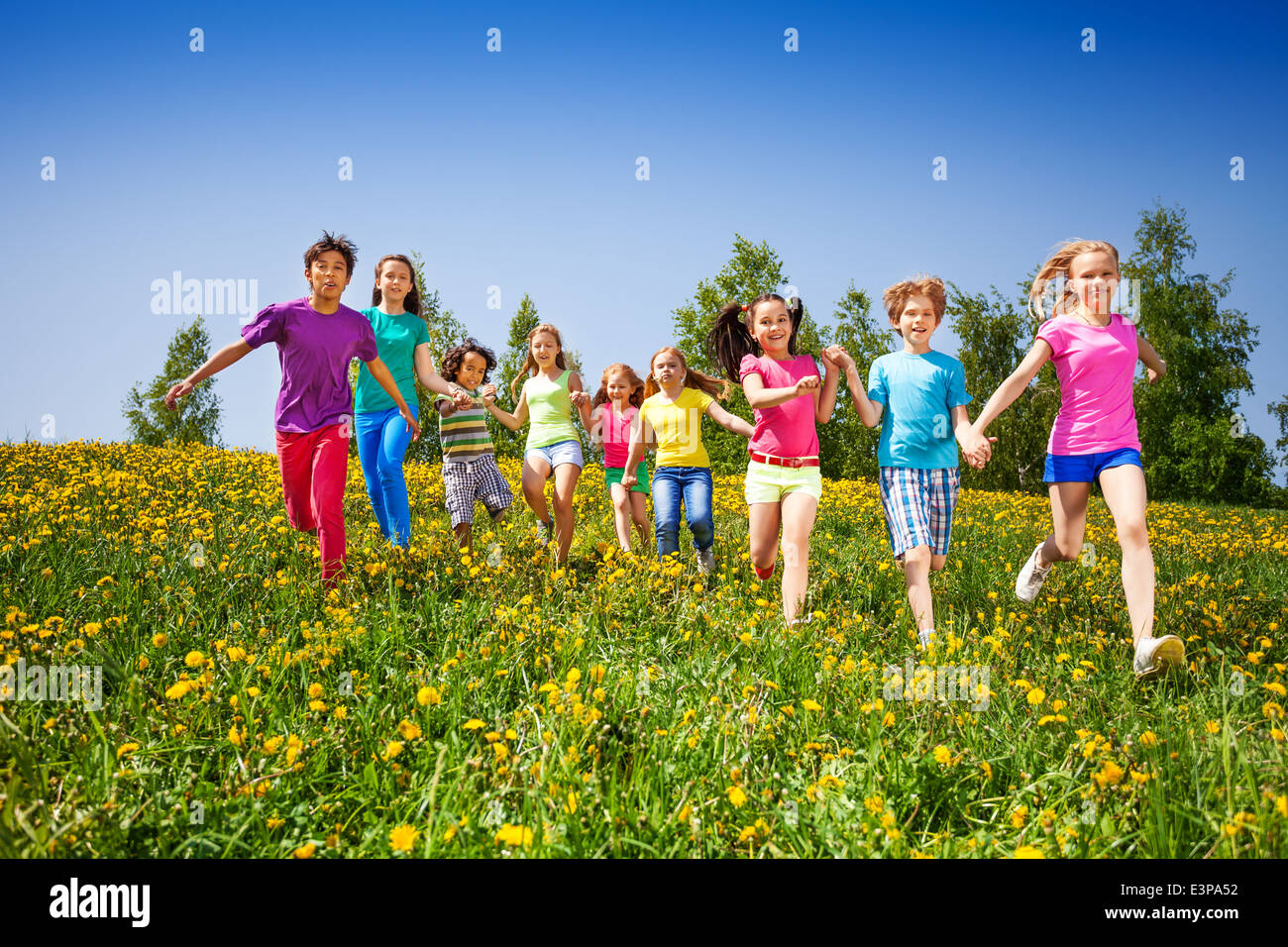 Running happy kids holding hands in green field Stock Photo - Alamy