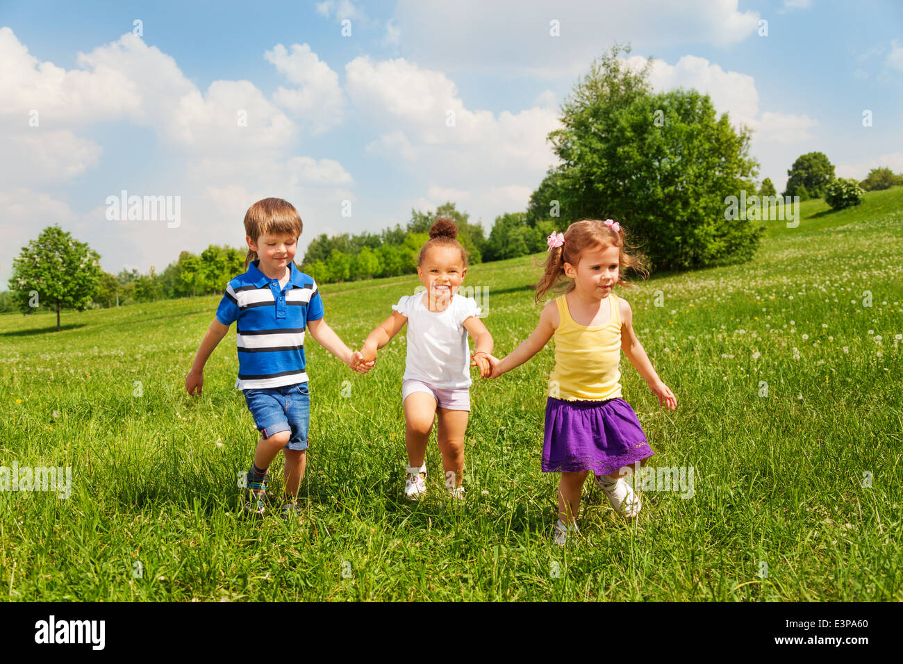 Three happy children holding hands and playing Stock Photo - Alamy