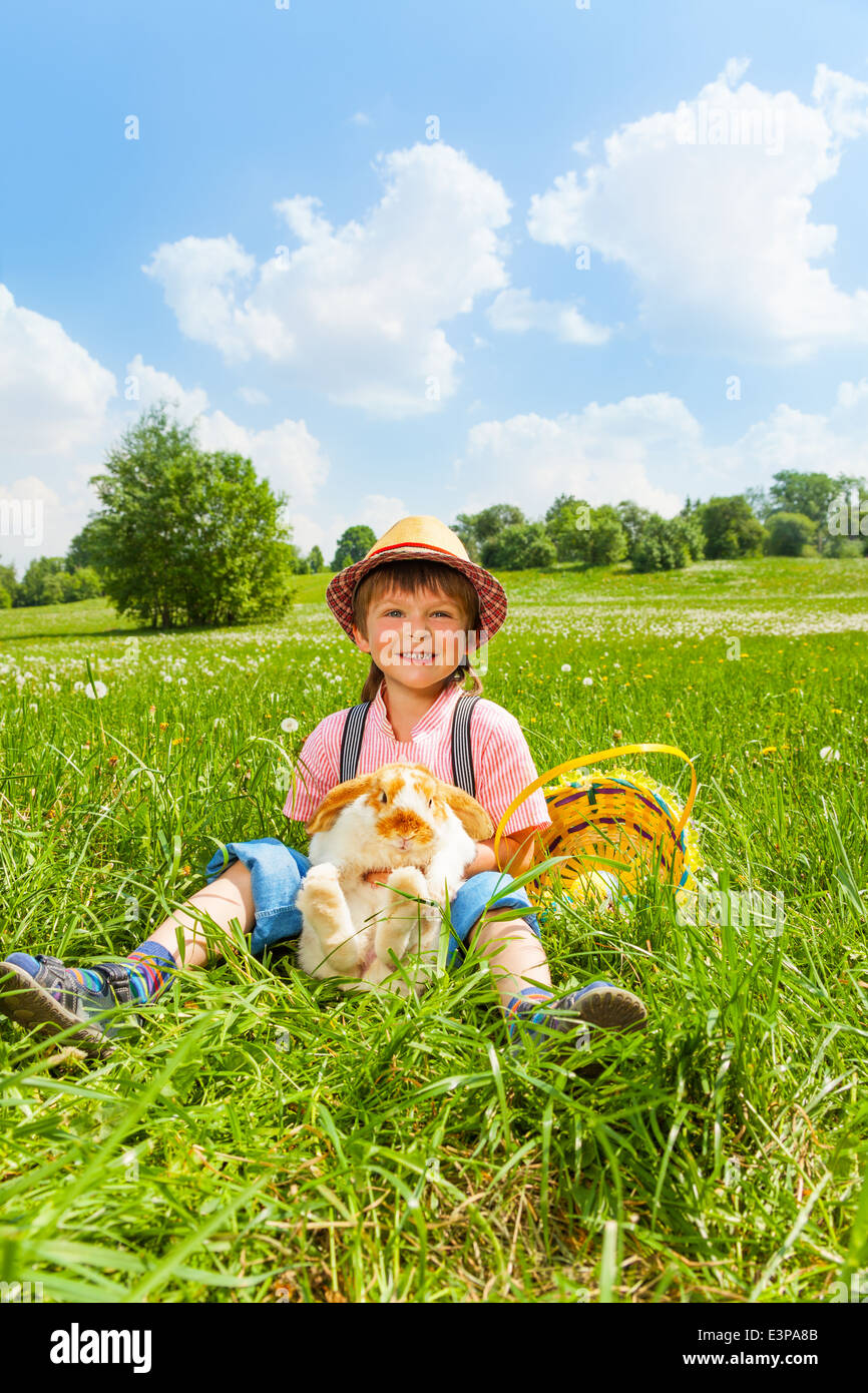 Positive boy wearing hat and hugging rabbit Stock Photo - Alamy