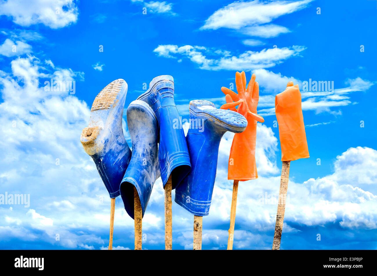 rubber boots hanging on blue sky background Stock Photo - Alamy