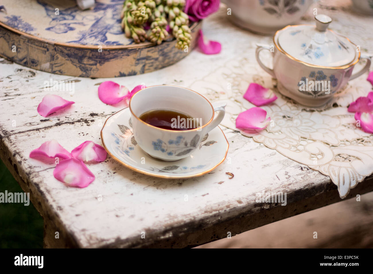 Old fashioned tea set in the garden with roses and petals Stock Photo ...
