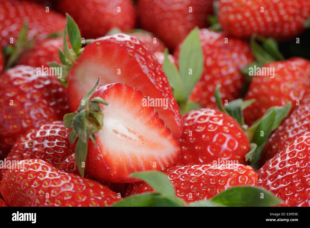 fresh ripe strawberry with half in front, close up Stock Photo - Alamy