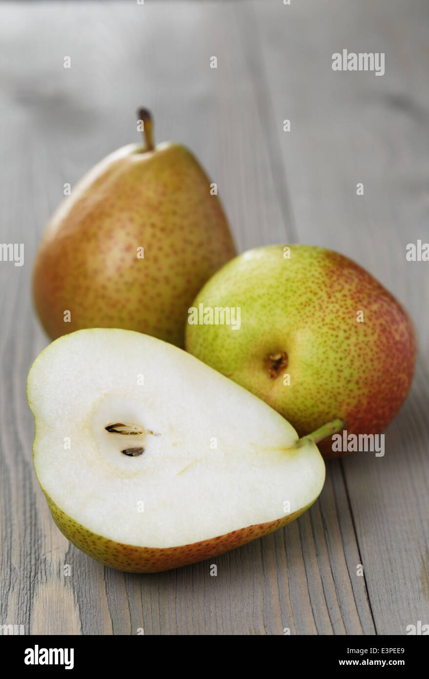 forelle pears with half on wood table, rustic style Stock Photo - Alamy