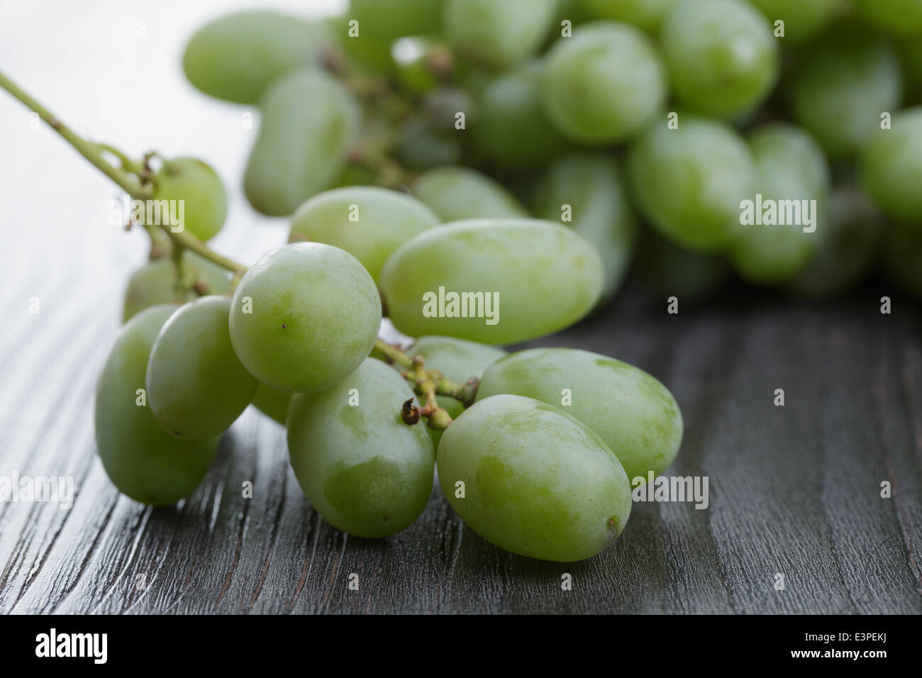ripe green grapes on black wood table, close up Stock Photo - Alamy