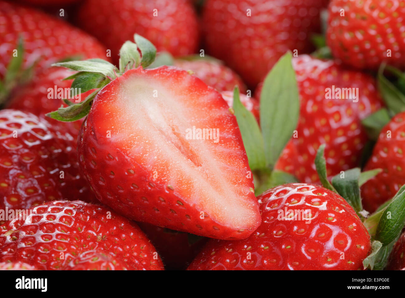 fresh ripe strawberry with half in front, close up Stock Photo - Alamy