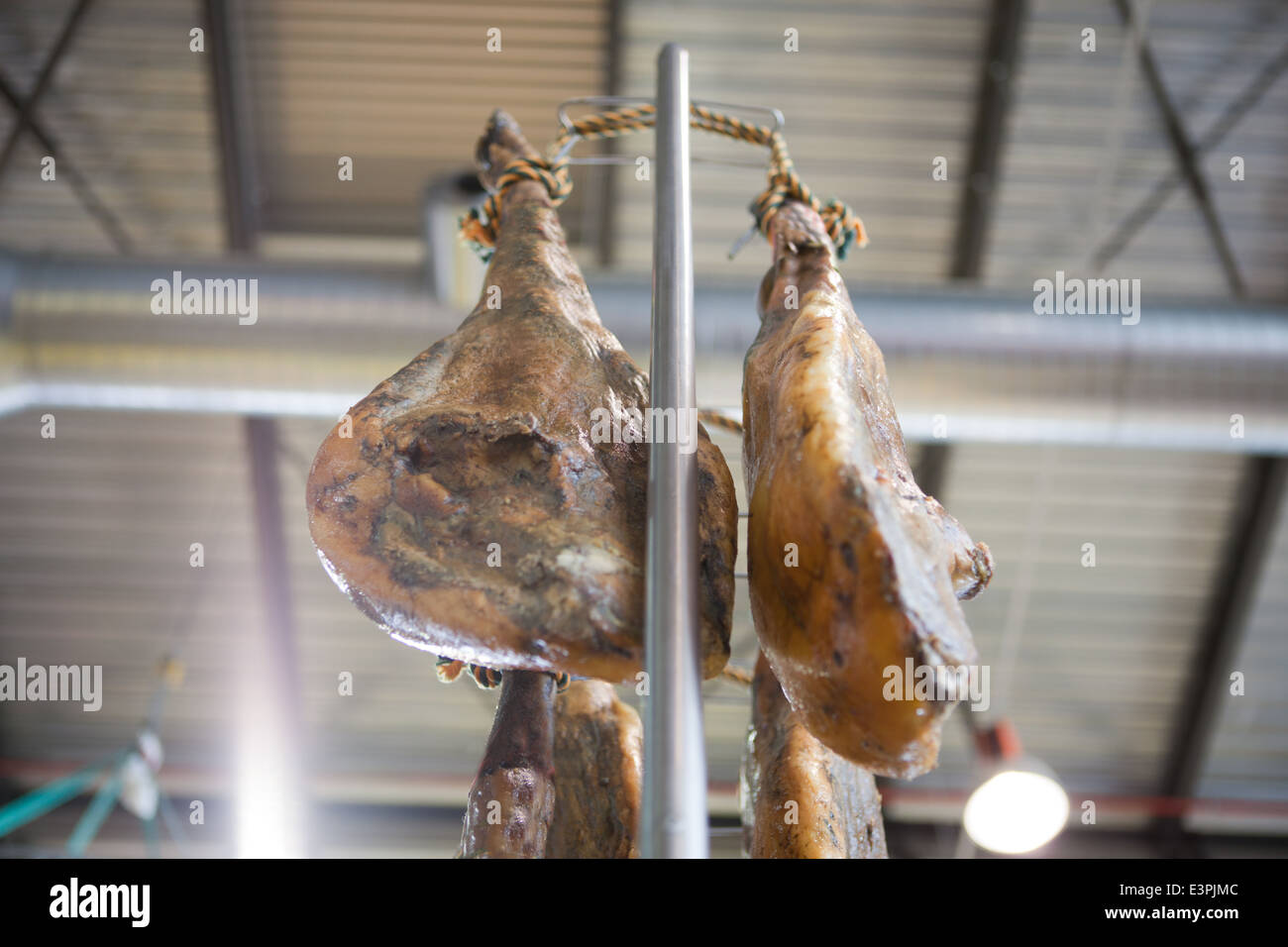 Serrano Ham and Jamon Iberico hanging in a shop. The jamon Iberico ...