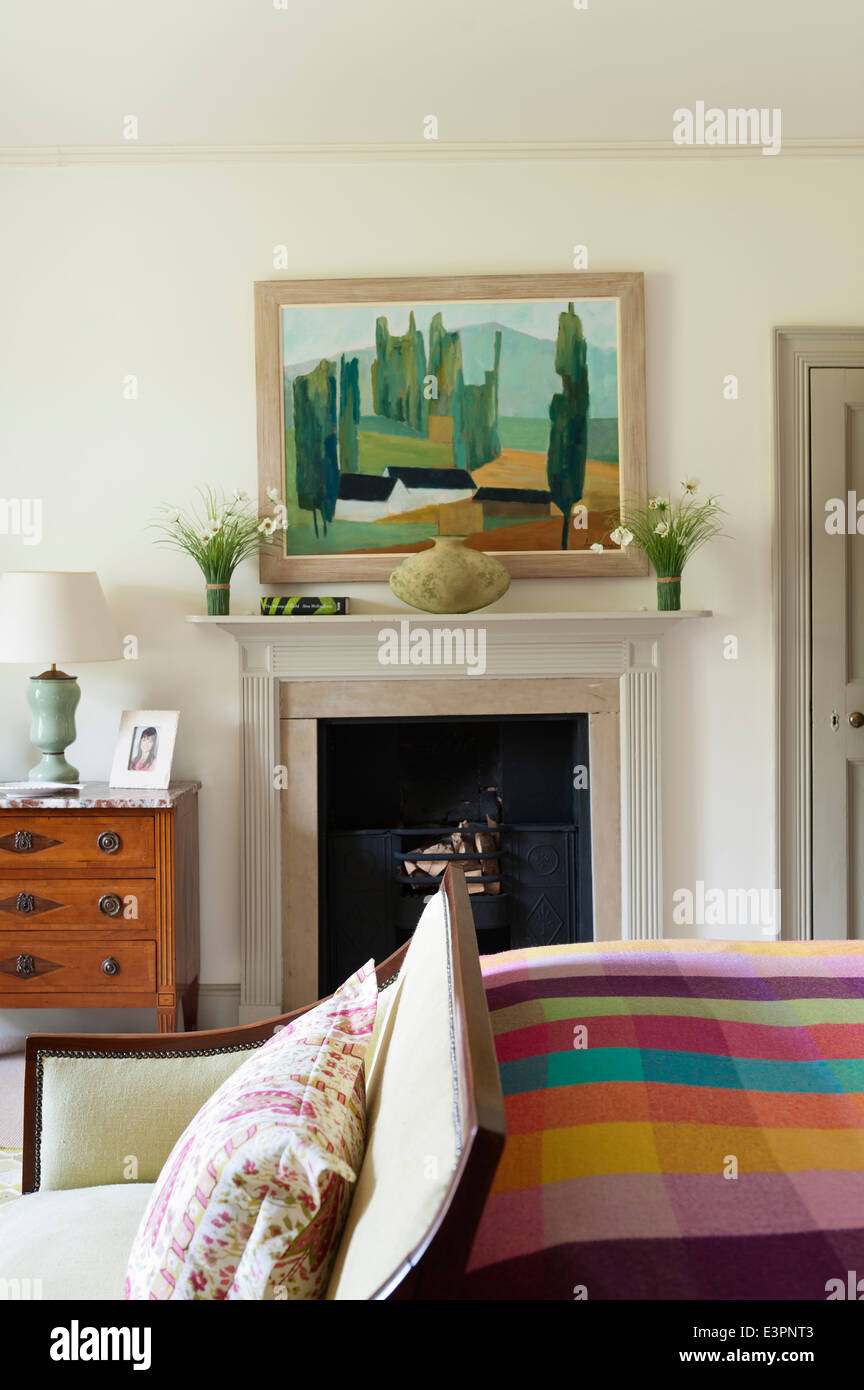 Landscape painting by Jeremy Fraser above chimney piece in bedroom with ...