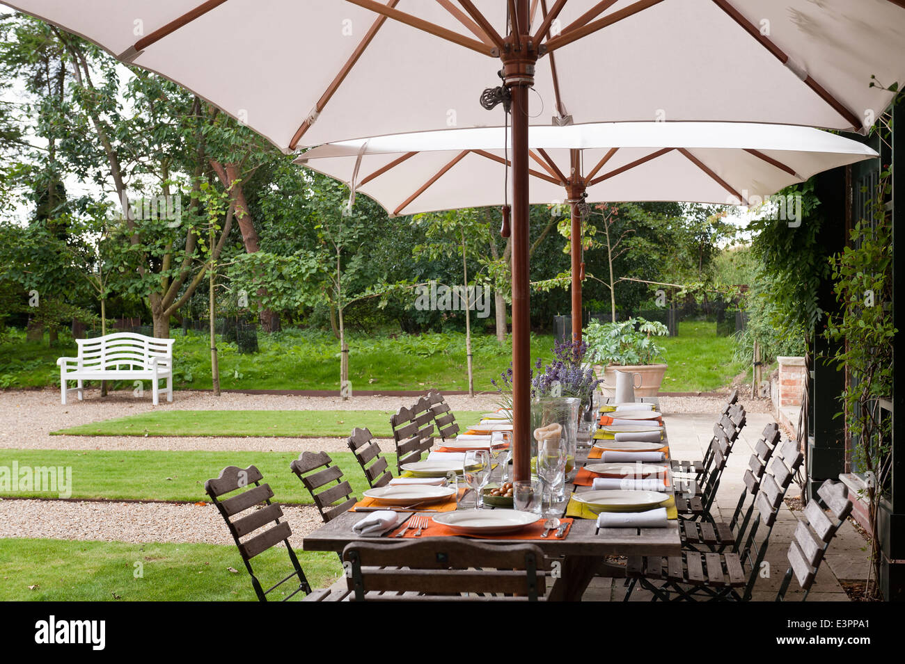 Large parasols cover an outdoor table laid for lunch Stock Photo - Alamy