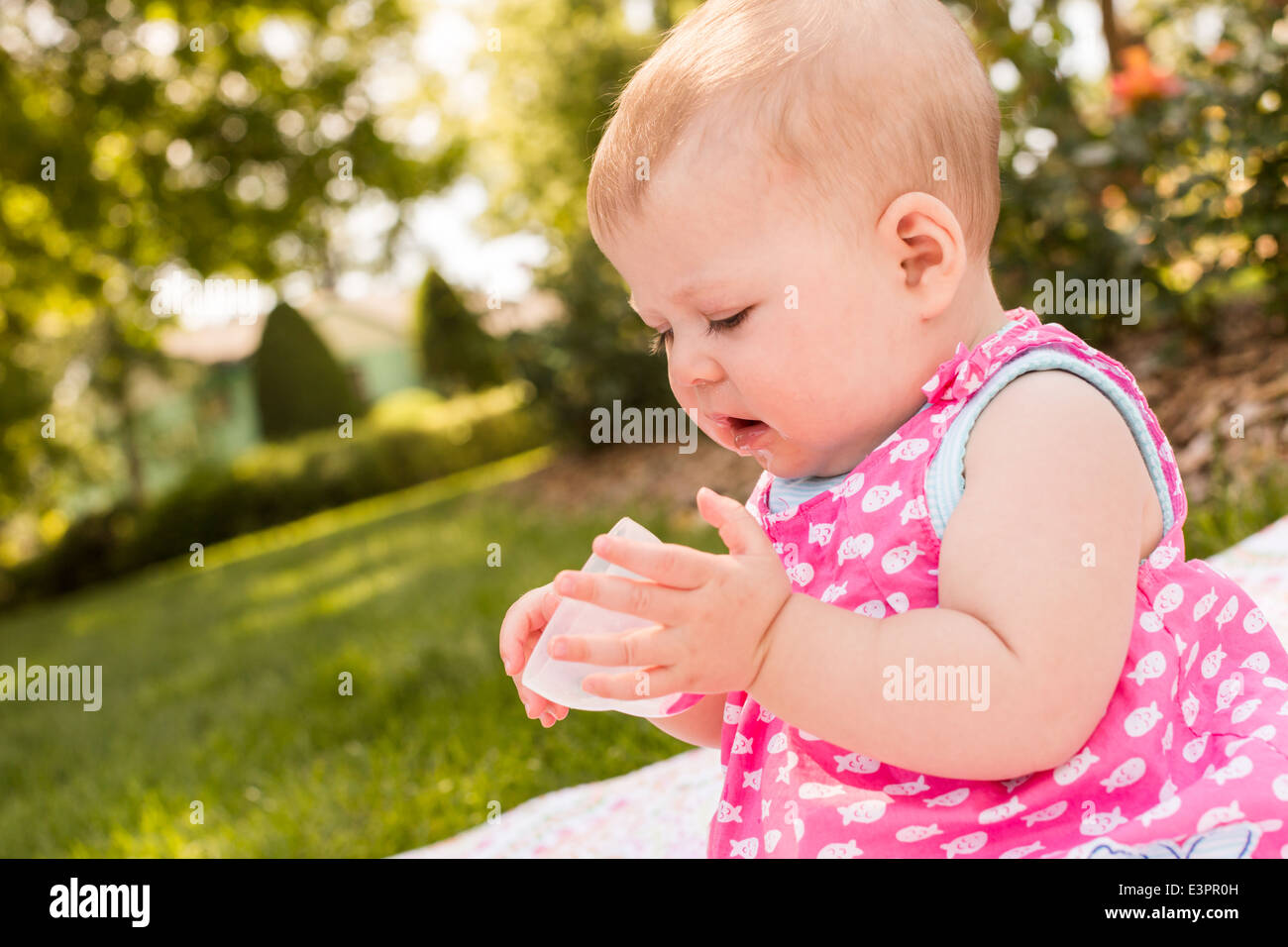 Cute baby girl playing on the blinket in the park Stock Photo - Alamy