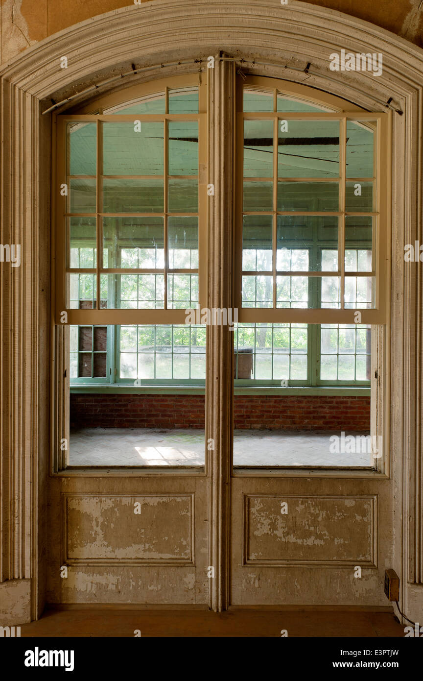 Distressed arched window with view through to sunroom with glass ...