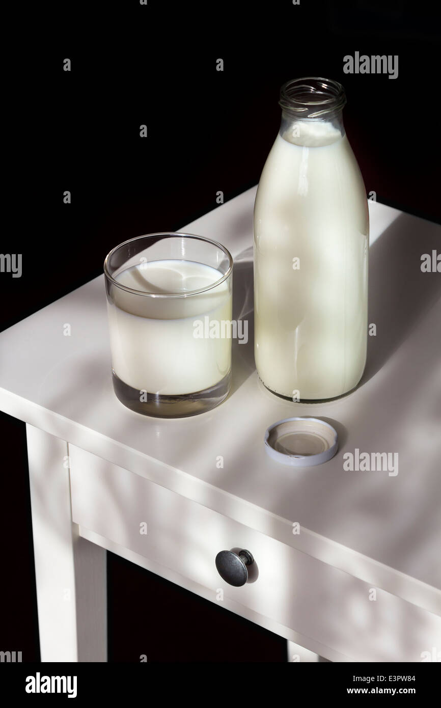 A Glass and a Bottle of fresh milk on a night table Stock Photo - Alamy