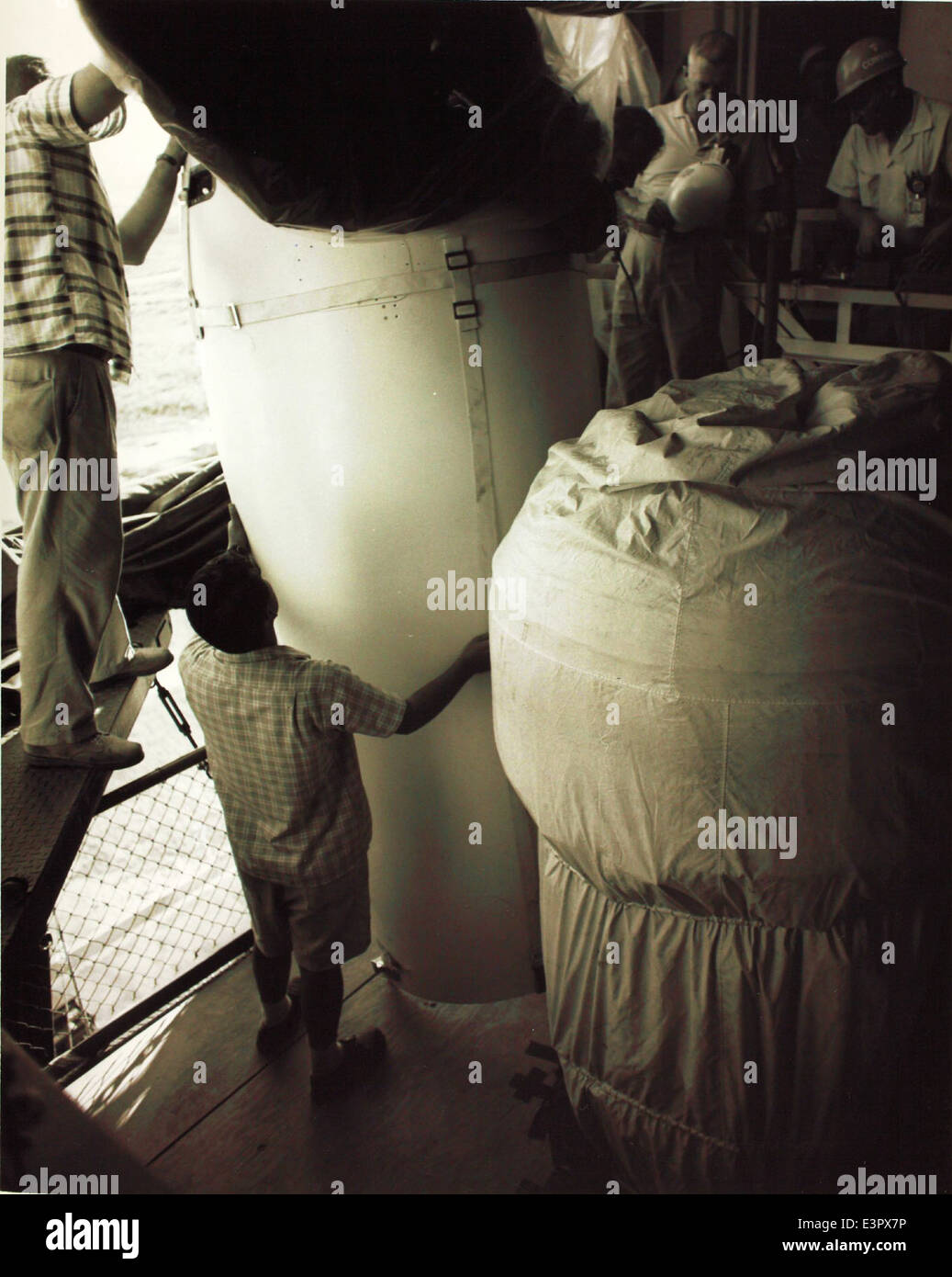 This 1960 image shows the installation of fairings on the payload for ...