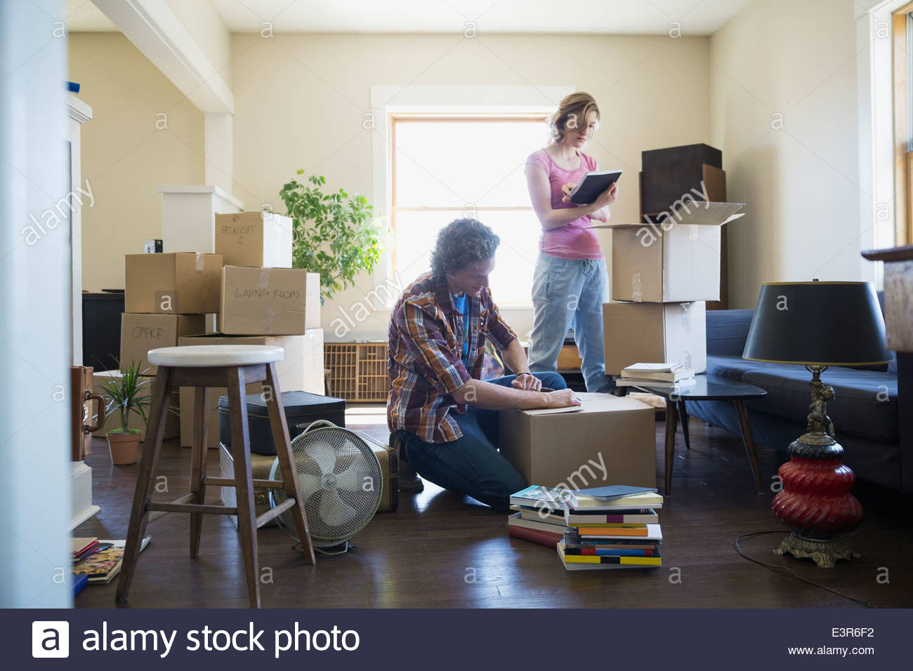 Couple packing moving boxes in living room Stock Photo - Alamy