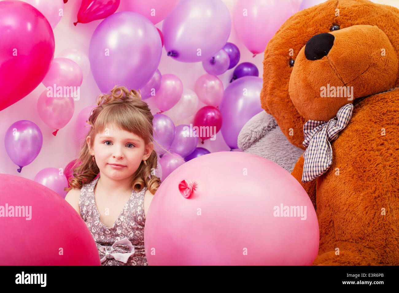 Beautiful curly girl posing among pink balloons Stock Photo - Alamy