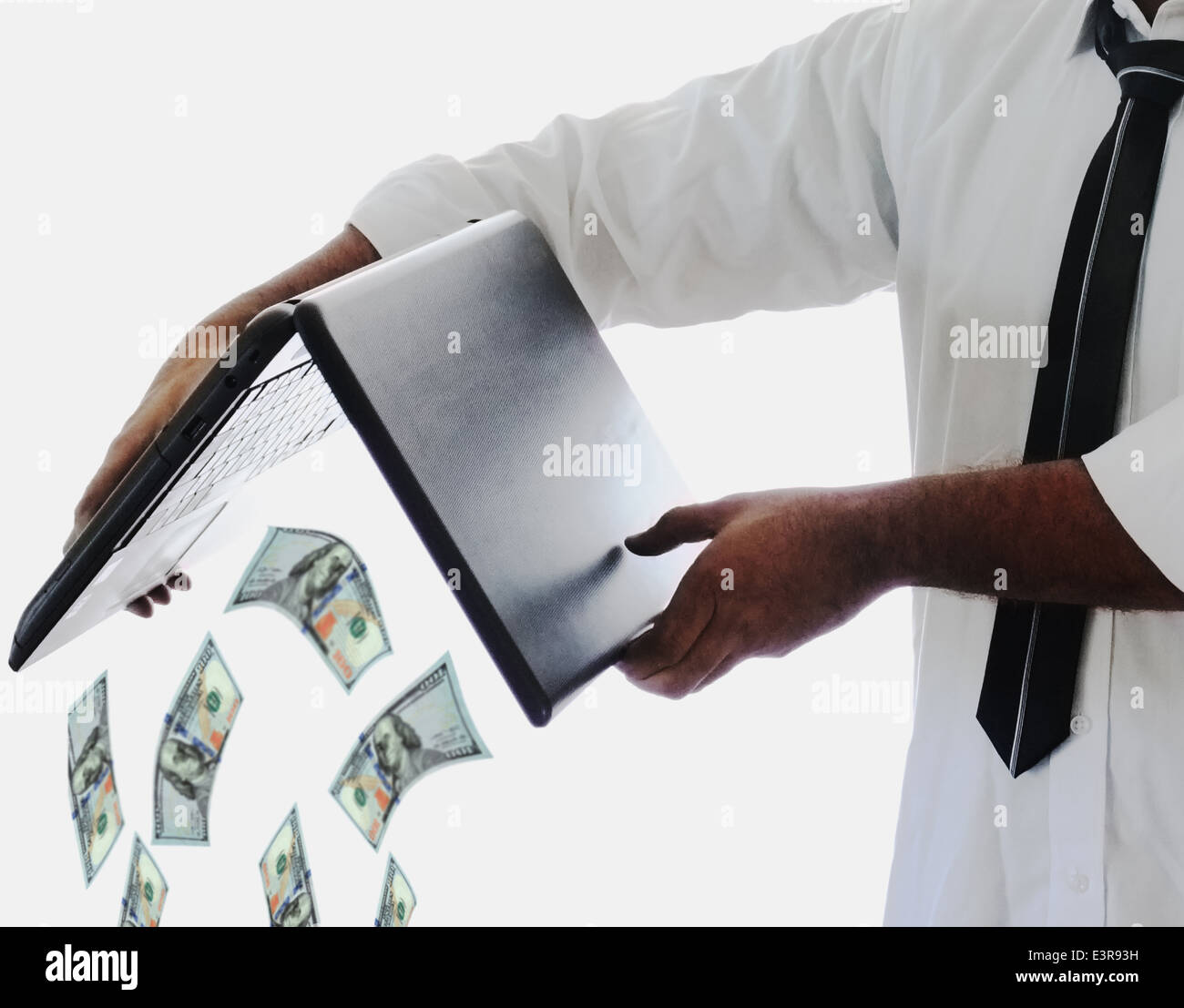 Man throwing money from laptop Stock Photo - Alamy