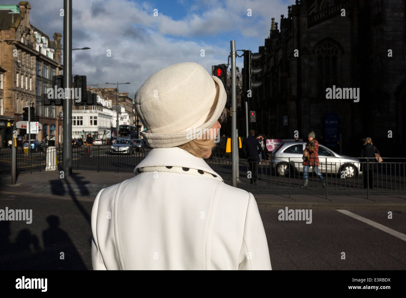 A blond woman in white clothes waits the traffic light in Princes ...