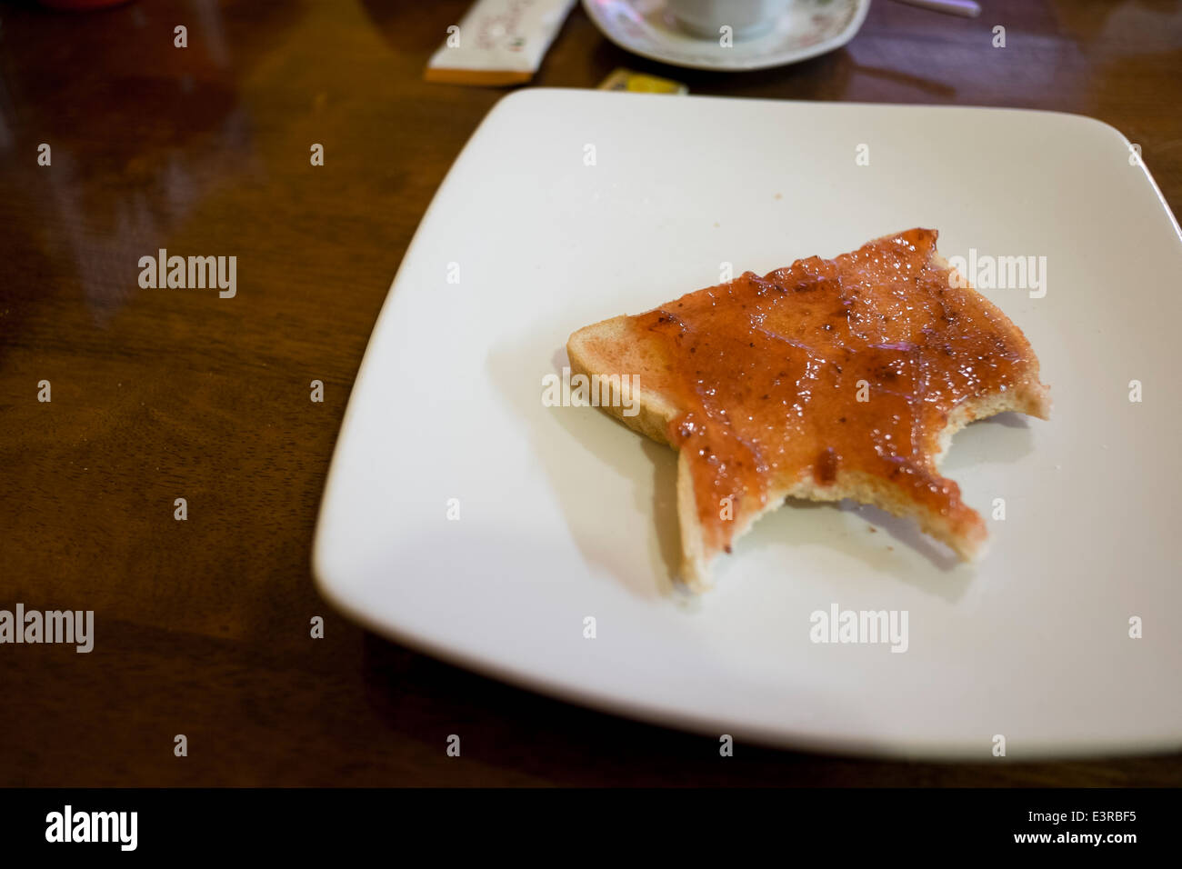Bitten slice of bread with jam Stock Photo - Alamy