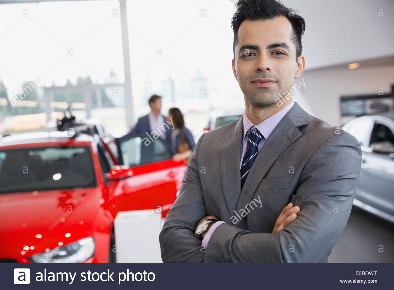 Portrait of confident salesman in car dealership showroom Stock Photo ...