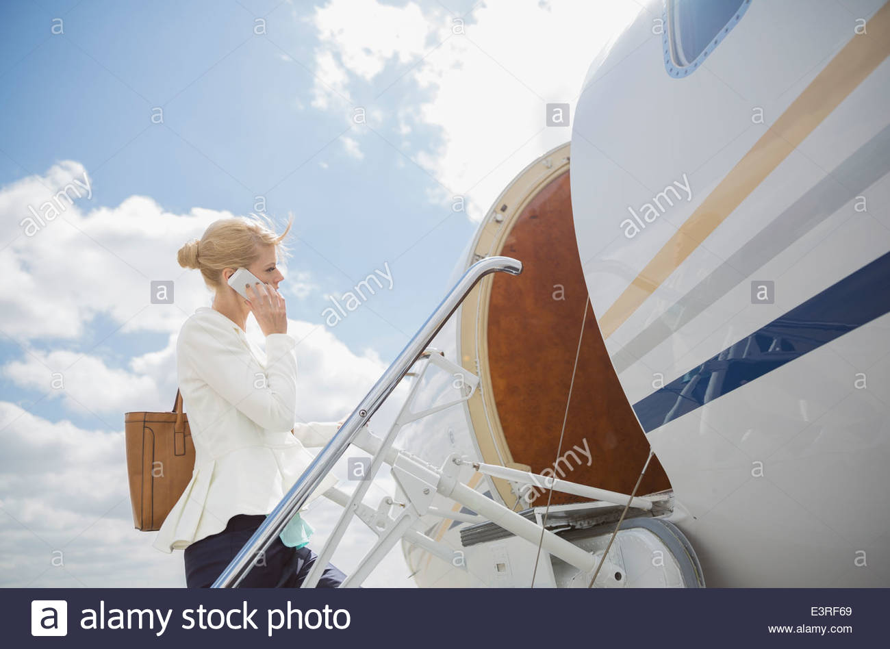 Businesswoman boarding corporate jet Stock Photo - Alamy