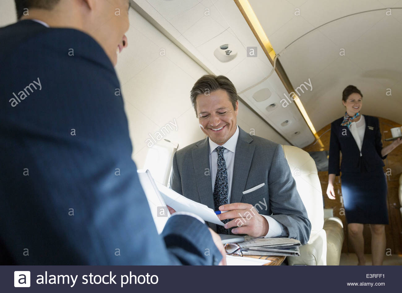 Businessmen working on corporate jet Stock Photo - Alamy