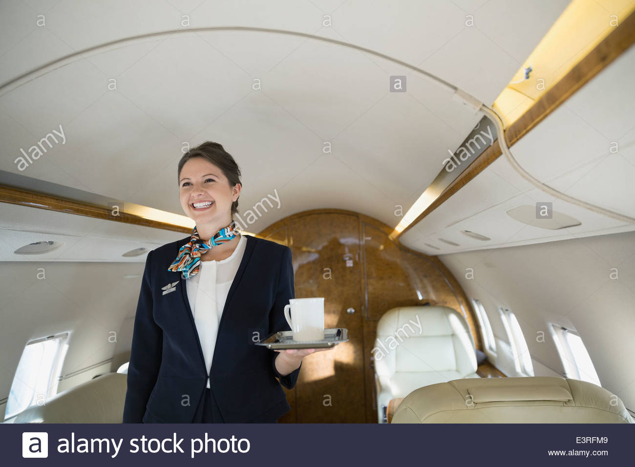 Flight attendant with coffee cup on corporate jet Stock Photo - Alamy