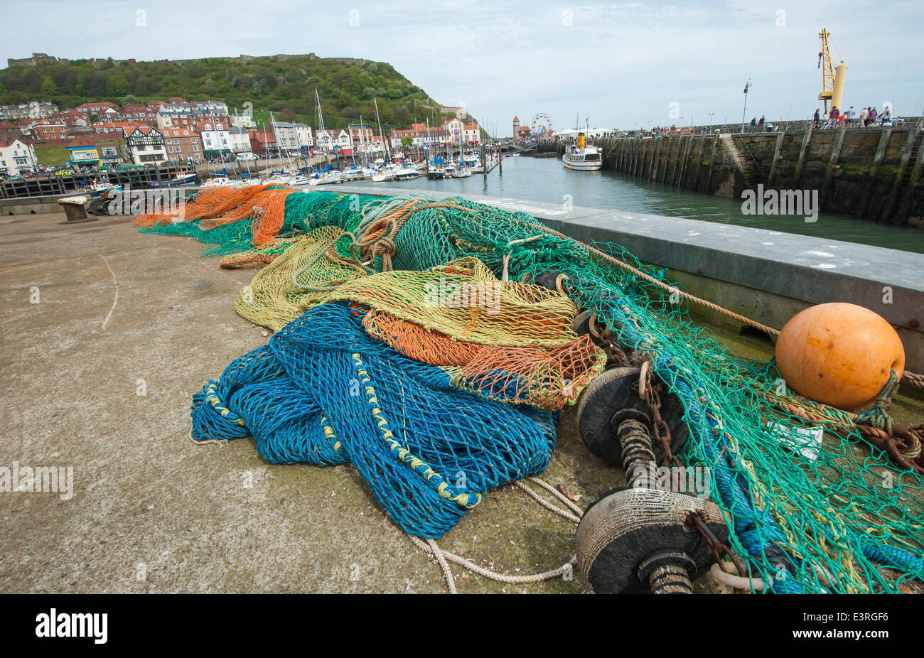 Trawler commercial fishing nets lying on quayside of english harbour ...
