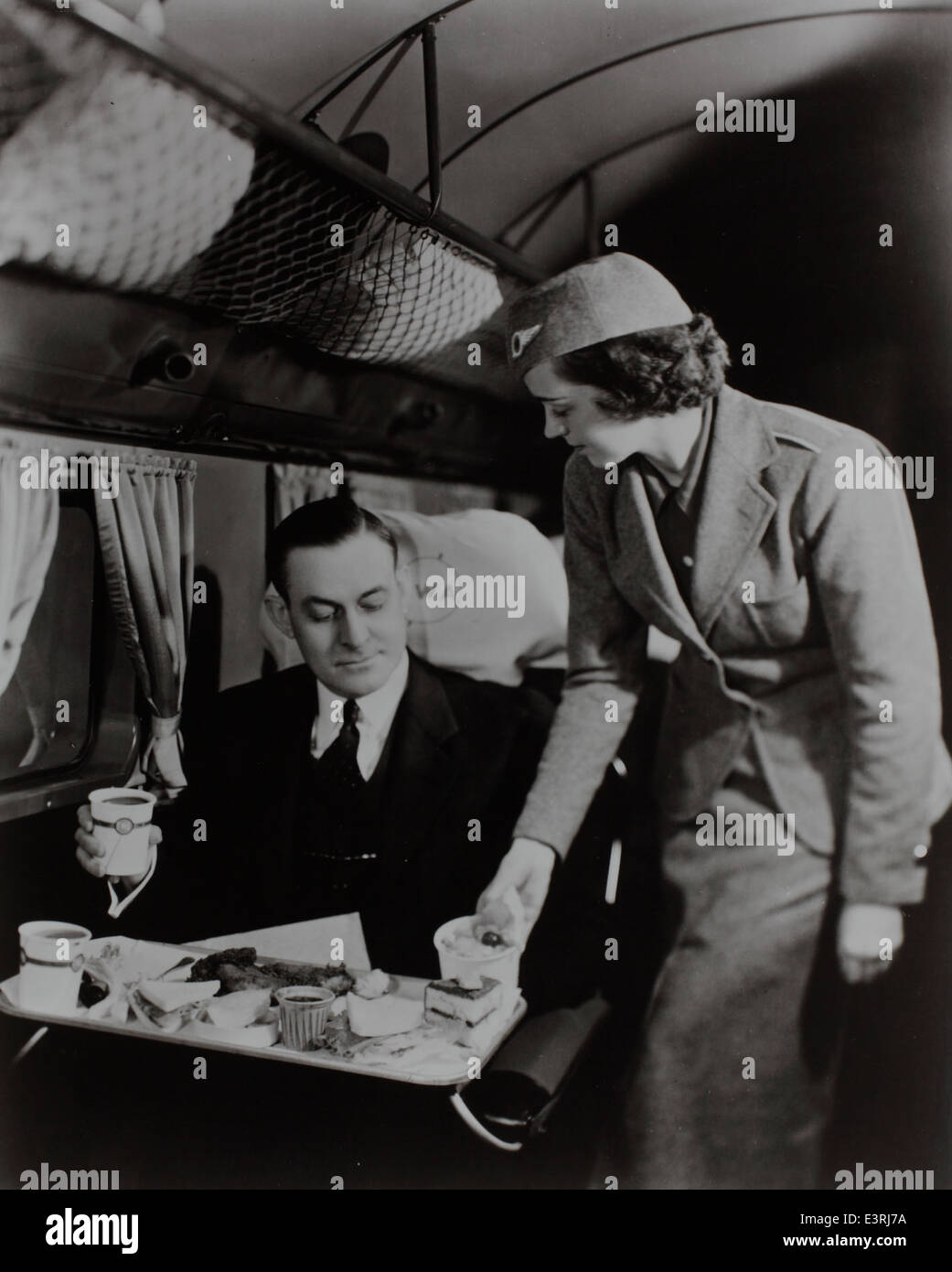 This historical photo showcases a stewardess at work, exemplifying the ...