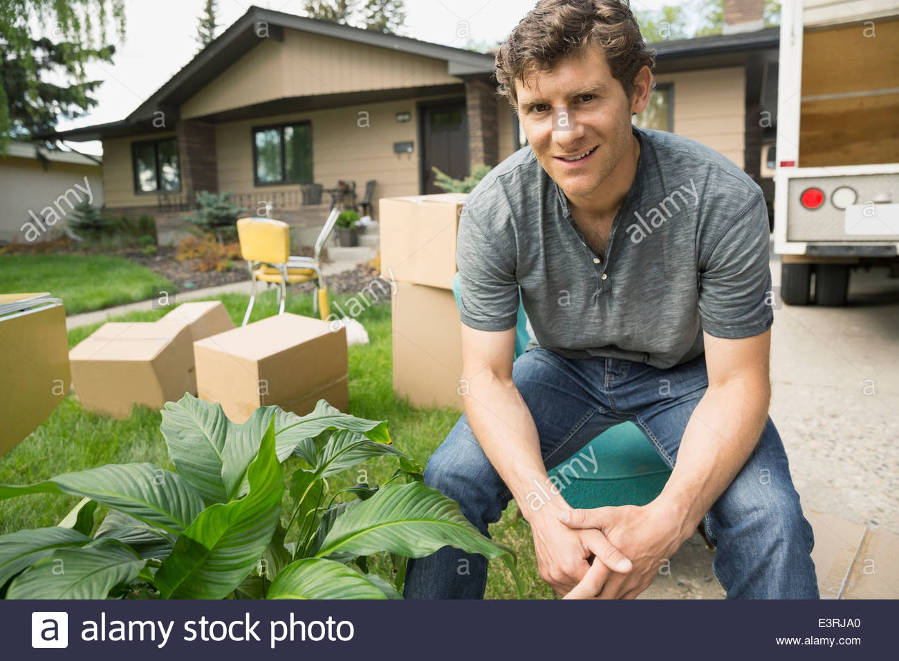 Portrait of confident man sitting outside moving van Stock Photo - Alamy