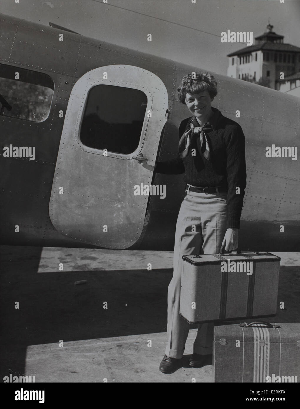 This photograph shows Amelia Earhart beside her aircraft in 1937, a ...