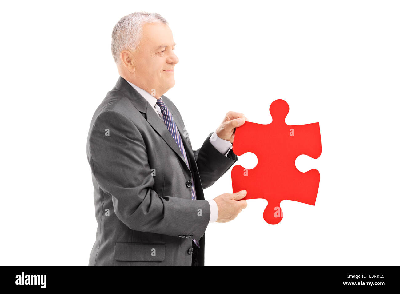 Mature businessperson holding a piece of puzzle Stock Photo - Alamy