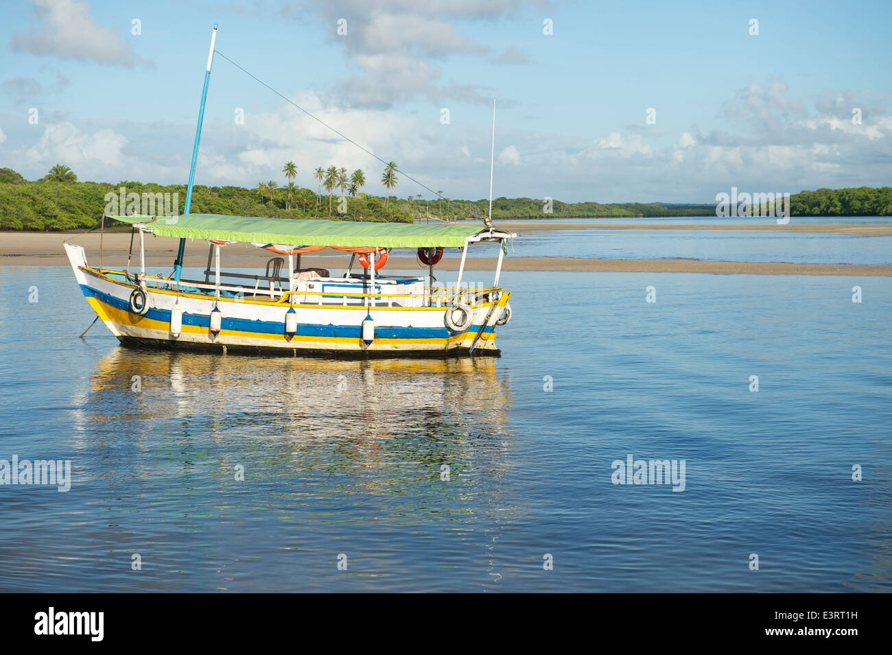 Brazilian boat floating off shore anchored in shallow waters on a ...