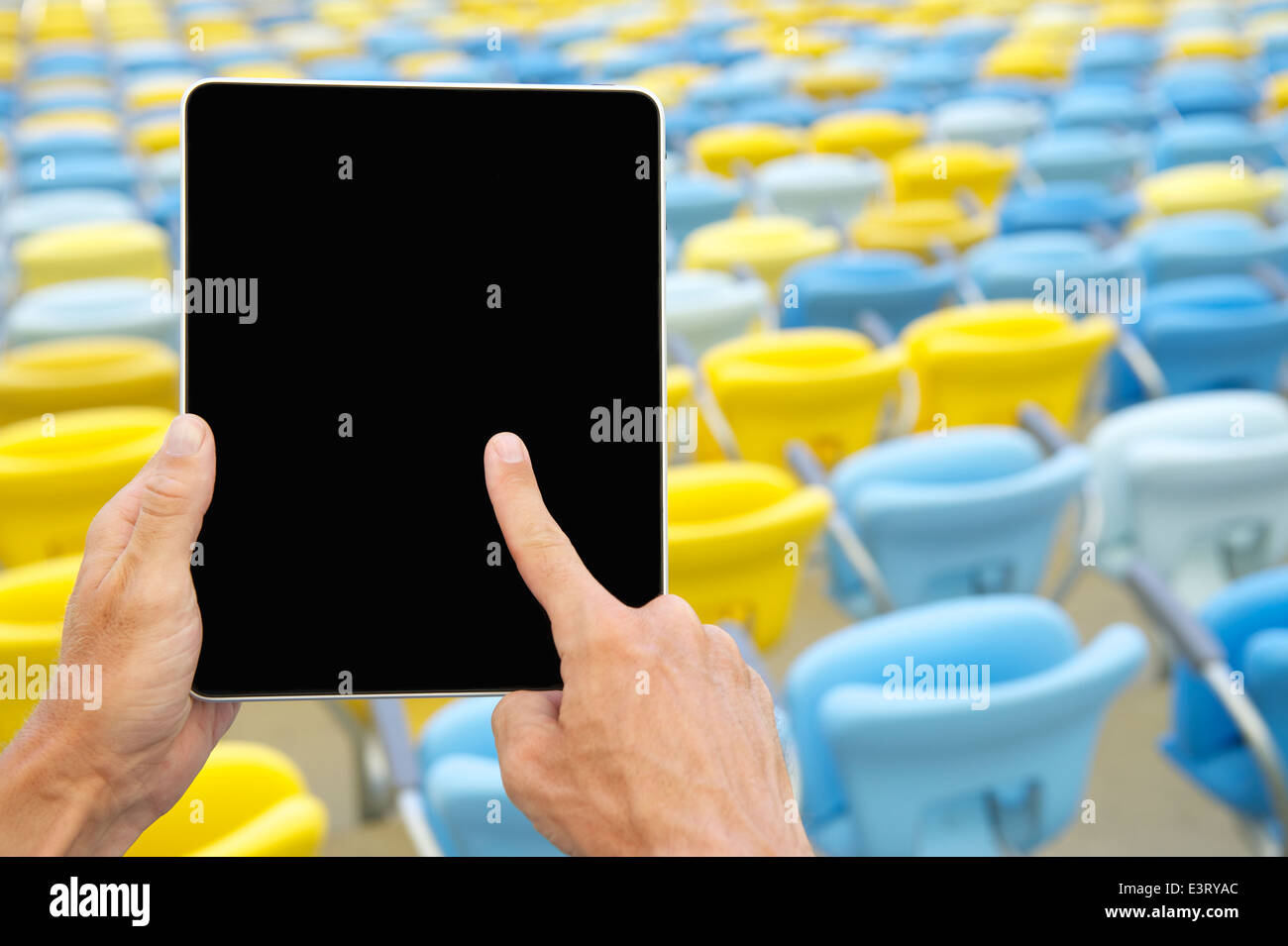 Hands using blank tablet computer in football stadium Rio de Janeiro ...