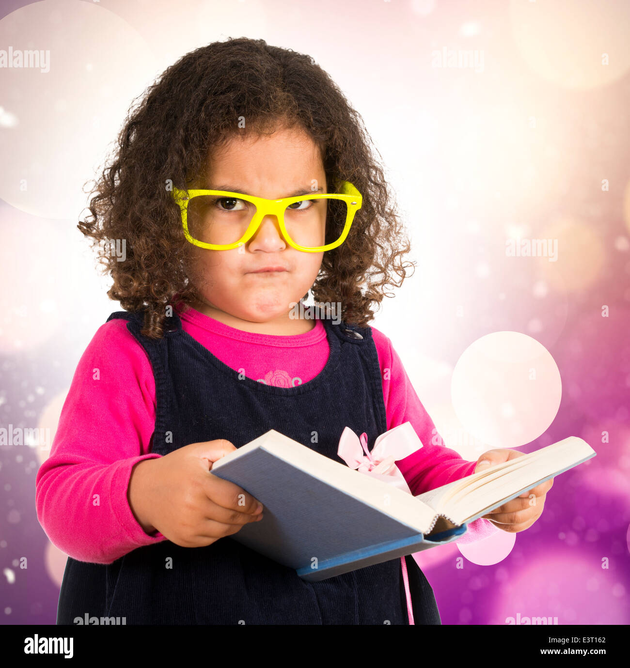 Little angry child holding the book Stock Photo - Alamy