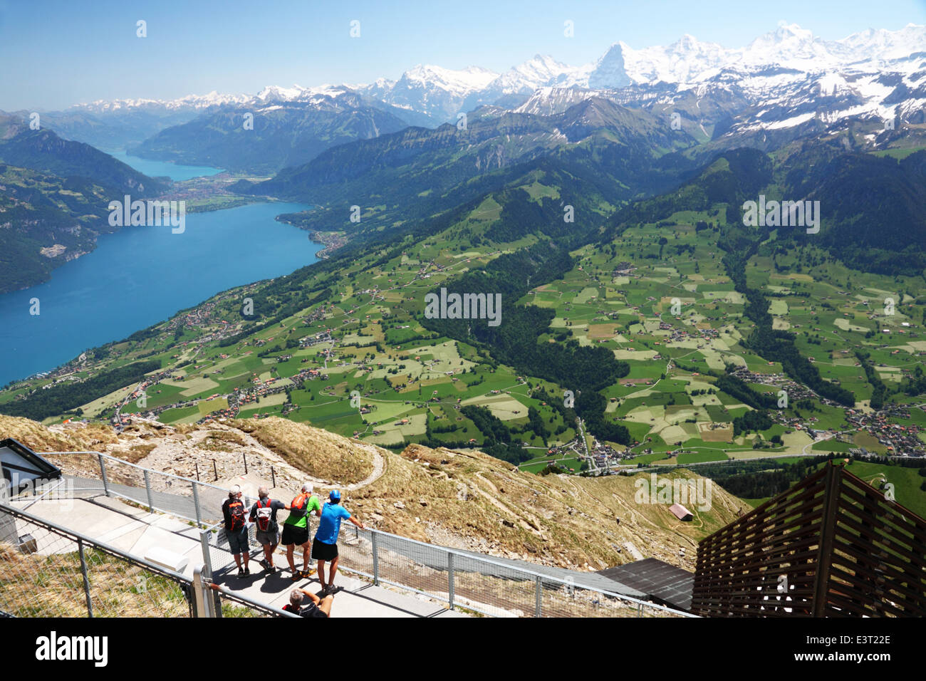 An overhead view of a blue lake in snow capped mountains with fields ...