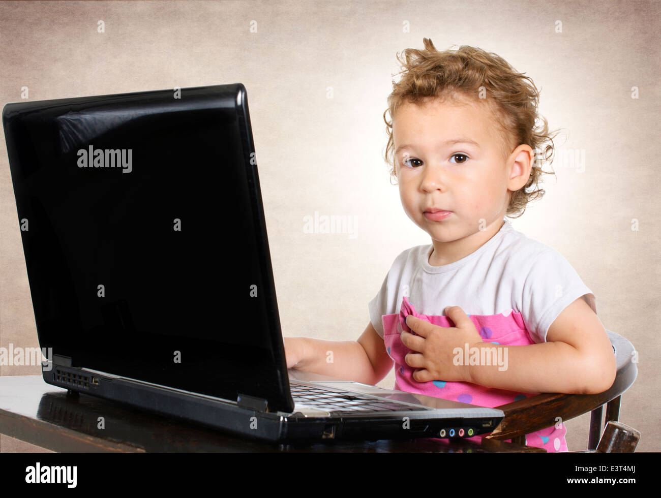 Little child sitting on the laptop computer and looking at camera Stock ...