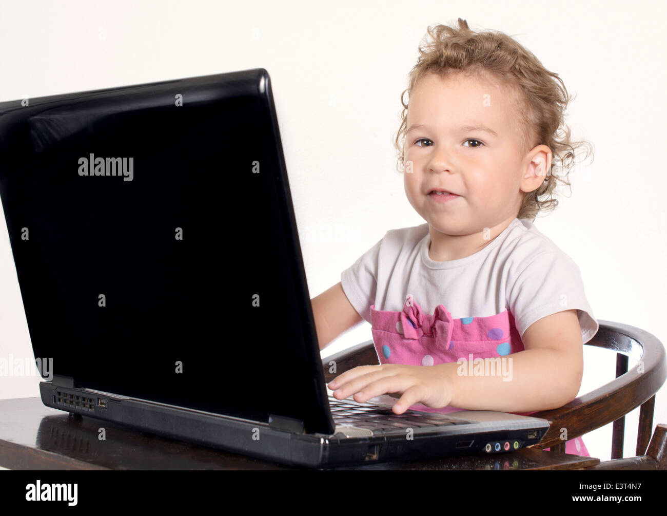 Positive little child typig the laptop computer Stock Photo - Alamy