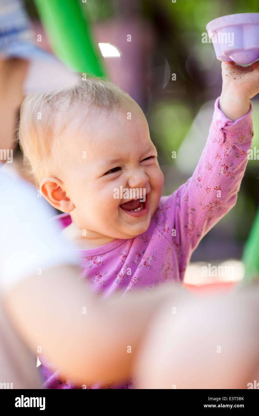 Laughing little baby playing with a toy Stock Photo - Alamy