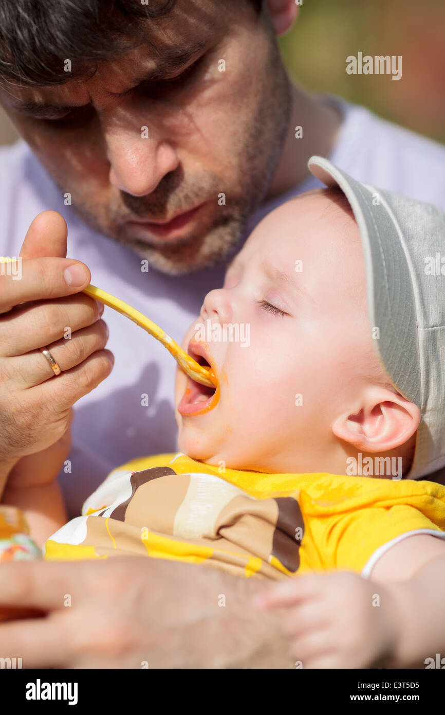 Daddy feeding toddler Stock Photo - Alamy