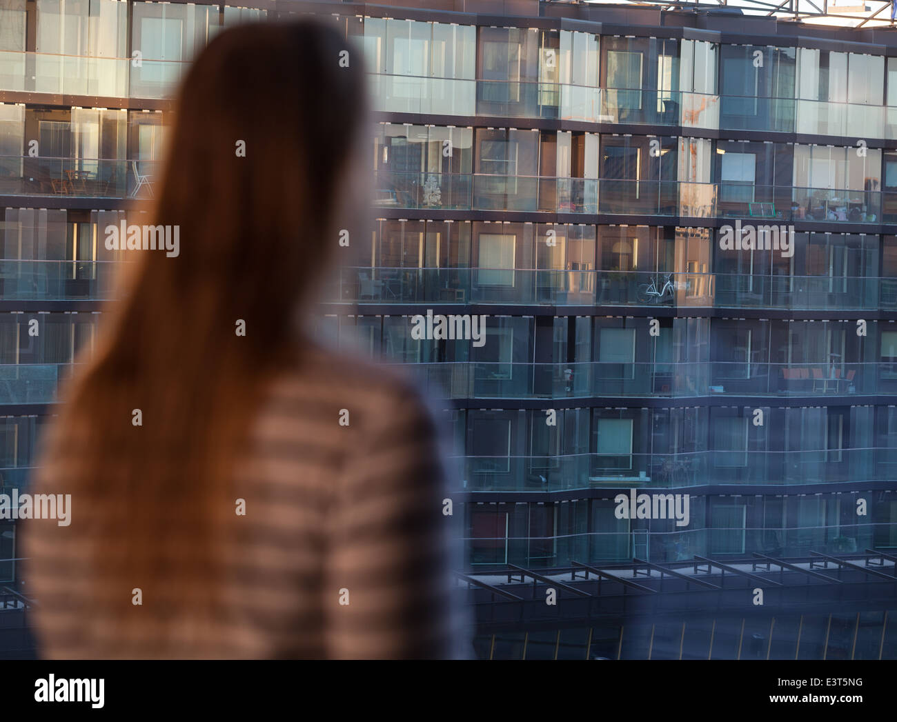 Woman looking at an apartment block Stock Photo - Alamy