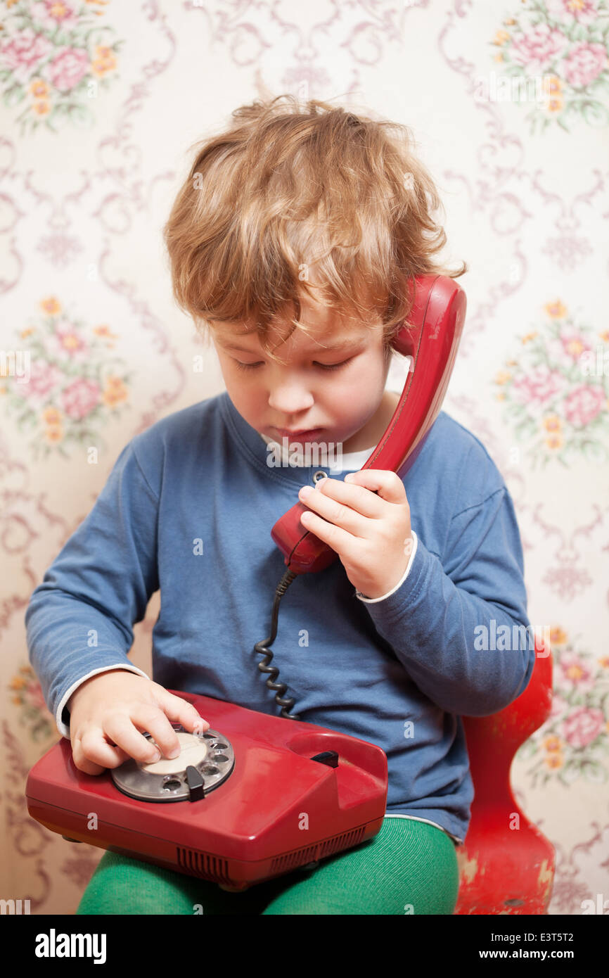 Small boy talking on a red telephone Stock Photo - Alamy