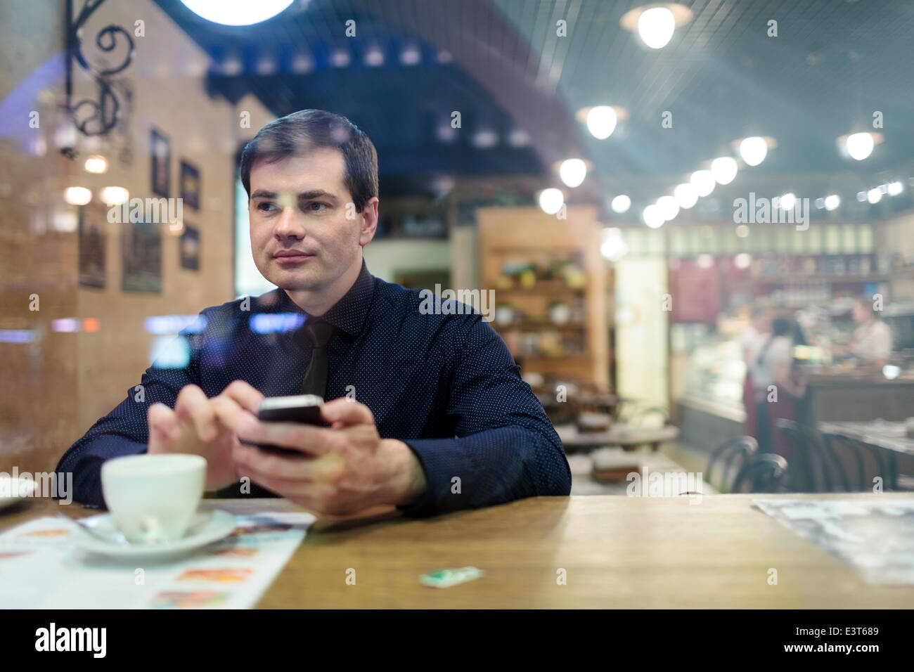 Man at the table texting Stock Photo - Alamy
