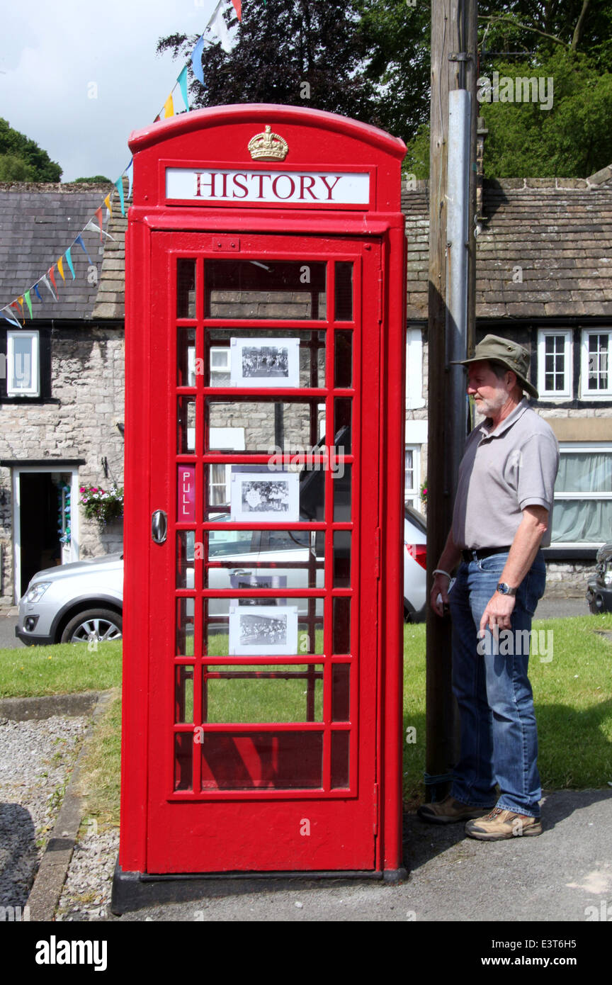 Tourist reading a poem on a converted phone box in the Derbyshire ...