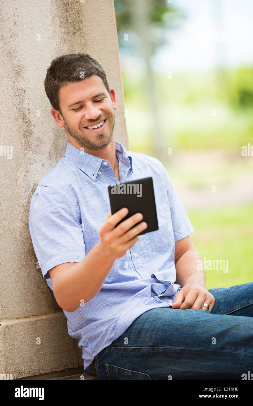 Young man reading E-book outside on steps Stock Photo - Alamy