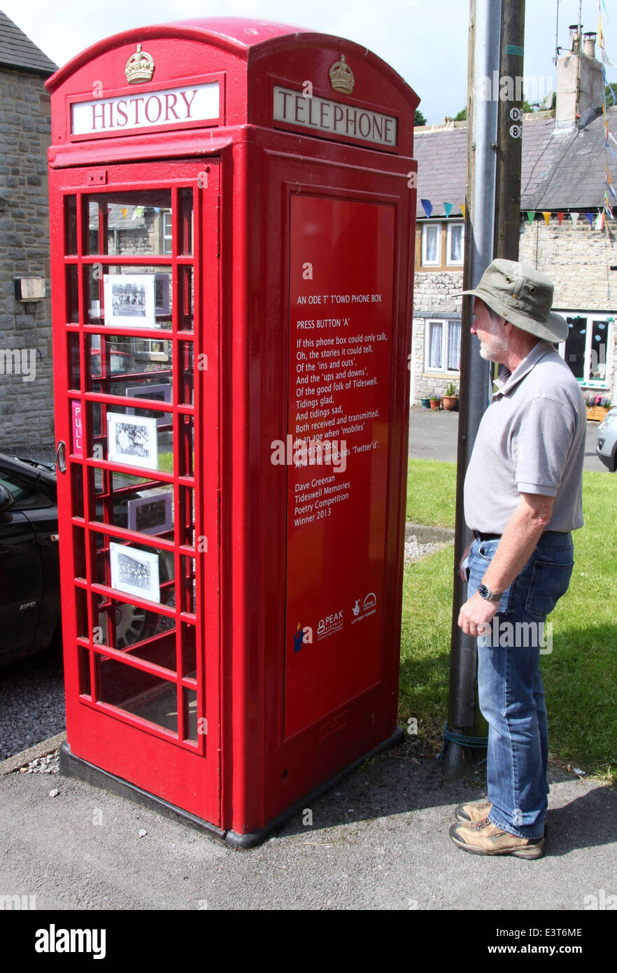 Tourist reading a poem on a converted phone box in the Derbyshire ...