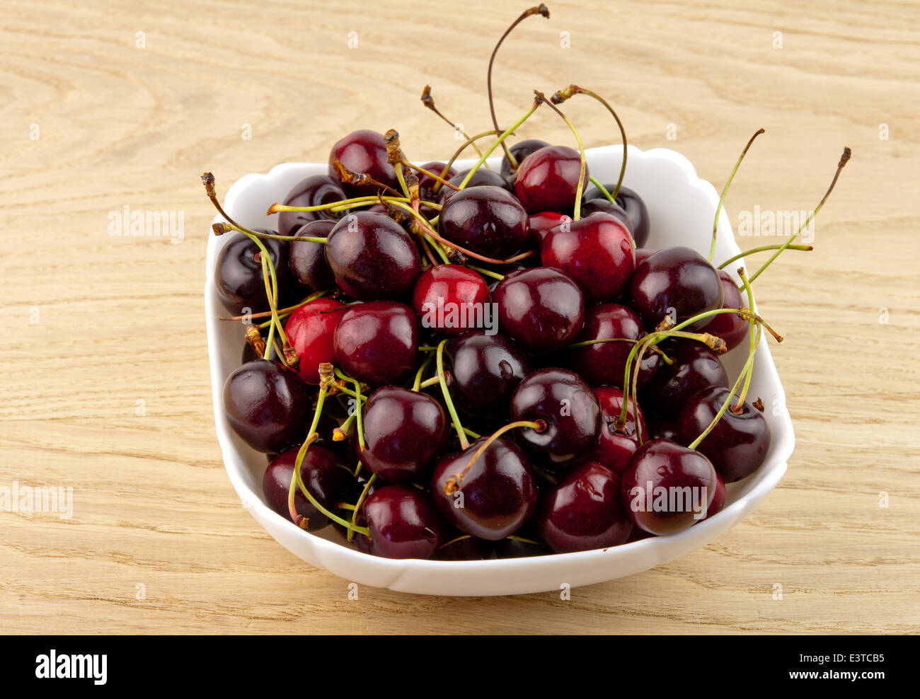 cherry in a dish on wooden table Stock Photo - Alamy